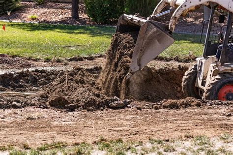 Premium Photo Small Bulldozer Digging In Yard For Pool Installation