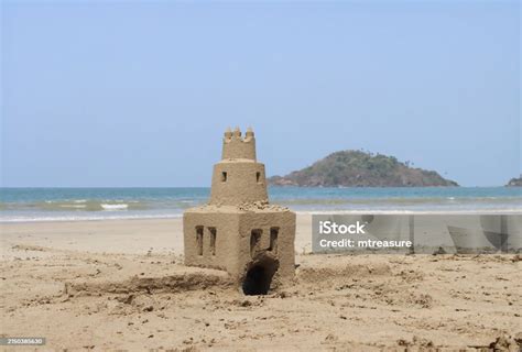 햇볕이 잘 드는 모래 해변의 모래성 이미지 썰물 때 부서지는 파도 바다와 해안선 전경에 초점 여름 휴가 및 관광 개념 복사 공간