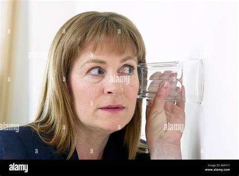 Woman Listening To Conversation Through Wall With An Ear To A Glass