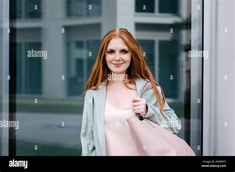 Beautiful Redhead Businesswoman With Purse In Front Of Window Stock