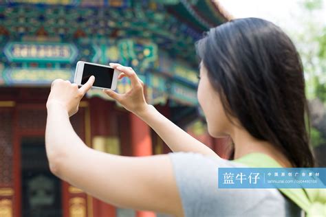 年轻女子在雍和宫用手机拍照 蓝牛仔影像 中国原创广告影像素材