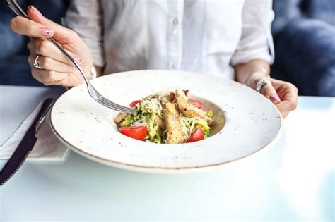 Woman Holding Fork And Plate Of Food At Restaurant Table Stock Image
