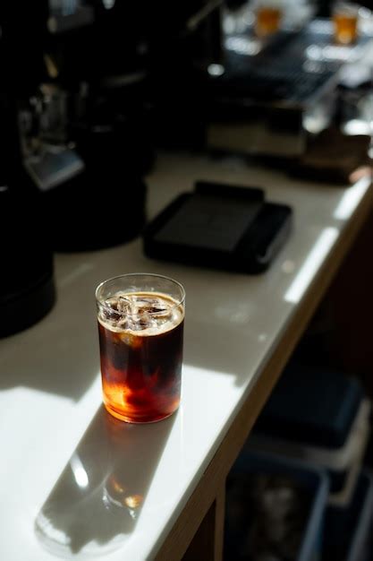 Premium Photo Coffee In A Glass With Ice Cubes On The Bar Counter