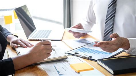 전문 비즈니스 파트너가 업무 공간 재무 및 투자 개념에서 작업 및 분석을 충족하는 아이디어 계획 및 프레젠테이션 프로젝트에 대해 논의하고 협업 팀워크가 데이터를 분석합니다