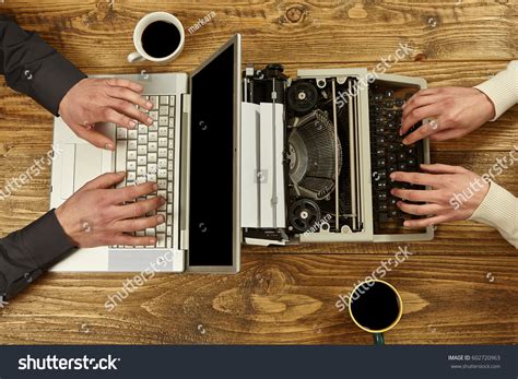 Stock Photo Woman Writing On A Typewriter And A Man Working On A Laptop Closeup To Hands