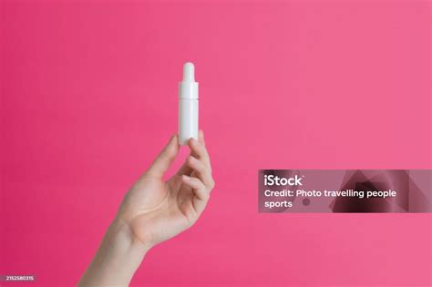 ピンクの背景にピペットと血清の白いガラス瓶またはエッセンシャルオイル高級化粧品のコンセプト エステティックサロンのストックフォトや画像を