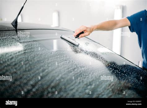 Male Specialist Work With Window Car Tinting Film Installation Process