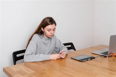 Premium Photo A Teenage Girl Sits At The Wooden Table And