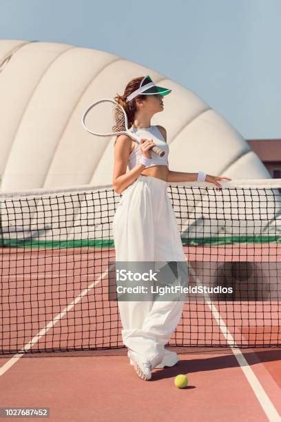 흰색 의류 및 테니스 라켓 테니스 코트에서 네트에서 포즈와 모자에 아름 다운 여자 경쟁에 대한 스톡 사진 및 기타 이미지 경쟁 공 스포츠 장비 낮 Istock