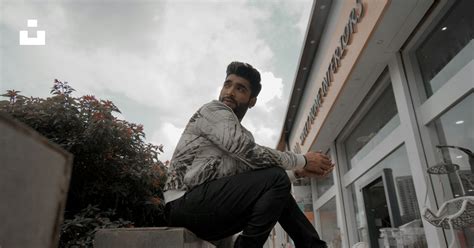 Foto Hombre Con Chaqueta Gris Y Pantalones Negros Sentado En Un Banco