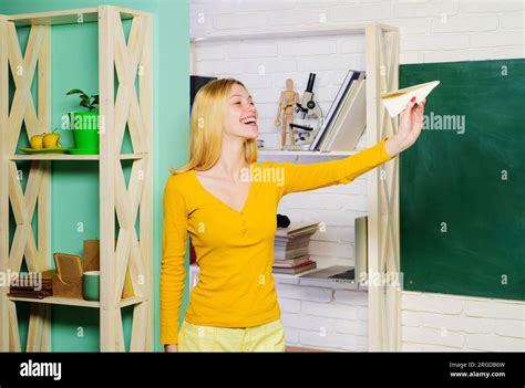 Smiling Student Woman Playing With Paper Airplane In Classroom Happy