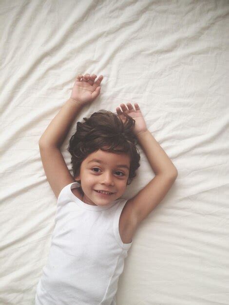 Premium Photo High Angle View Of Happy Girl Lying On Bed
