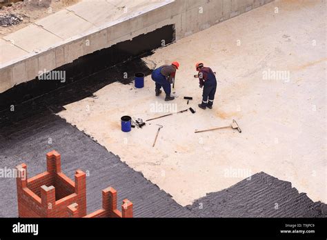 Two Workers Conduct Waterproofing Of The Roof With Bitumen View From Above Stock Photo Alamy