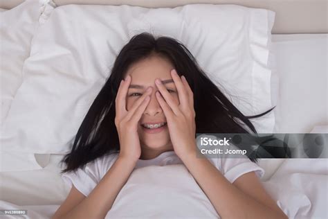 아름 다운 젊은 여 자가 그녀의 눈을 덮고 카메라 보고 침대에 누워 있는 동안 웃 고 가리기에 대한 스톡 사진 및 기타 이미지