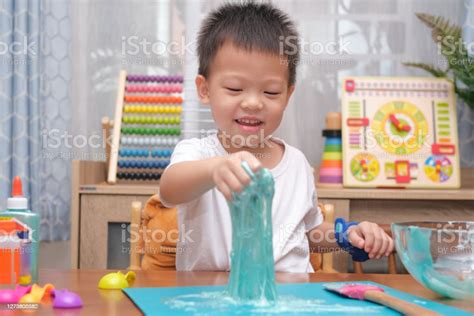 귀여운 아시아 4 세 소년 재미 만들기 푹신한 점액 젊은 아이 재미 재생 하 고 과학 실험에 의해 창조적 인 것 이라고