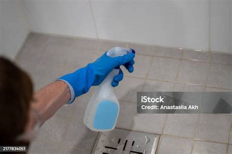 파란색 고무 장갑을 낀 남자의 손이 세제가 든 스프레이 병을 들고 있습니다 타일 바닥은 부분적으로 씻겨졌습니다 청소부에 대한 스톡 사진 및 기타 이미지 Istock