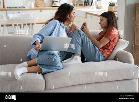 Mother And Daughter Using Devices Mom Spying On Kid On Internet Spending Time Together At Home