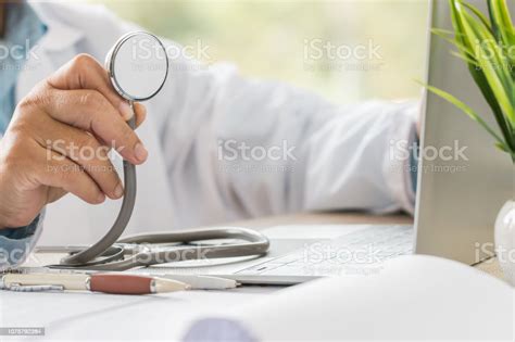 의학 의사 손 들고 Stethoscopes 실 클리닉 책상에 노트북 컴퓨터에서 작업을 컨설팅 청진 기 전경 테이블