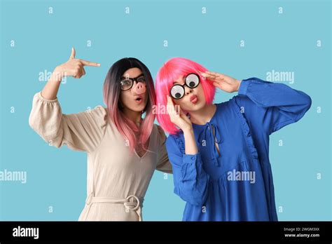 Beautiful Young Women In Funny Disguise Blowing Kisses On Blue