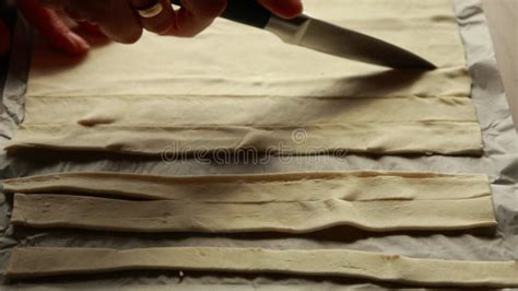 Woman Hands Cutting Strips From Puff Pastry With A Knife Closeup