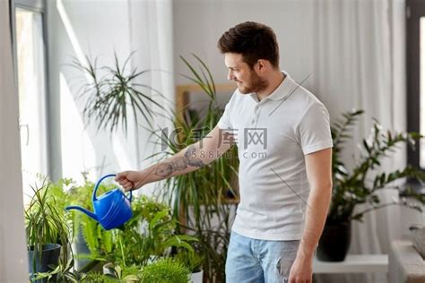 人、自然和植物护理概念 — 男人在家里浇盆栽植物。人物特写美女高清摄影大图 千库网
