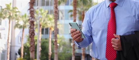 Panoramic Shot Of A Male Wearing A Blue Shirt With A Red Tie Holding A