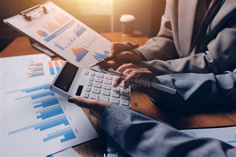 Group Of Confident Business People Point To Graphs And Charts To