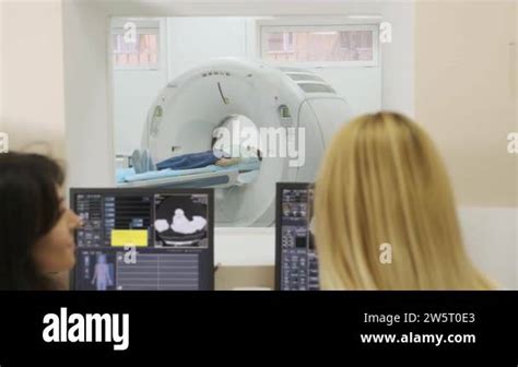 Two Qualified Radiologists Examines Female Patient Who Is Lying Under