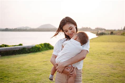 어머니 육아와 신생아 출산 생활 엄마와 아기는 공원 일몰에서 놀고 가족은 함께 즐거운 시간을 보내고 있습니다 육아 출산 개념