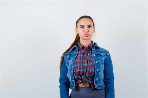 Jovencita Posando Mientras Mira Soplar Las Mejillas Con Camisa A
