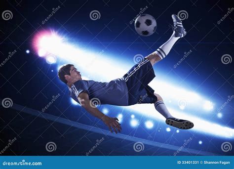 Soccer Player In Mid Air Kicking The Soccer Ball Stadium Lights At