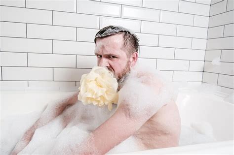 Premium Photo Displeased Weird Man With Soapy Sponge Puff In Mouth