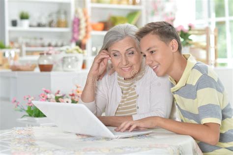 Abuela Con Nieto Usando Laptop En Casa Imagen De Archivo Imagen De