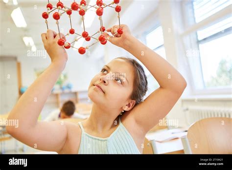 Curious Schoolgirl Examining Molecular Structure While Sitting In