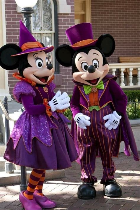 Two Mickey And Minnie Mouse Characters Standing Next To Each Other