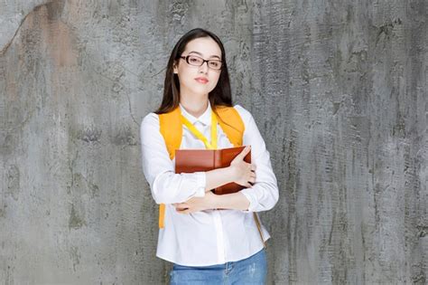 Retrato De Una Estudiante Con Gafas Sosteniendo Un Libro Foto De Alta Calidad Foto Gratis