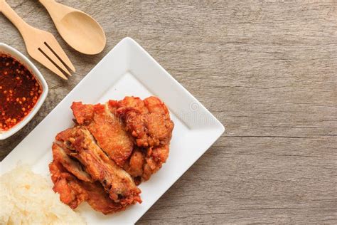 Thai Style Fried Chicken With Red Spicy Sauce And Sticky Rice On Wooden