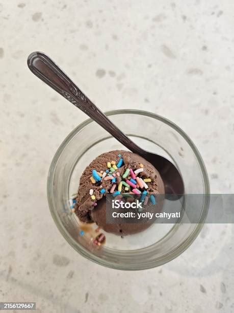 형형색색의 초콜릿 스프링클을 얹은 초콜릿 아이스크림을 투명한 유리 아이스크림 용기와 알루미늄 스푼에 담아 제공합니다 0명에 대한 스톡 사진 및 기타 이미지 Istock