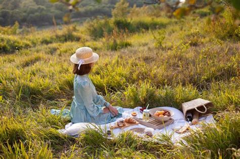Una Mujer Vestida De Azul Se Sienta En Un Picnic En Un Parque Con Vista