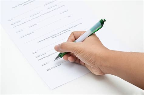 Premium Photo Close Up Of Hand Filling Document Over White Background