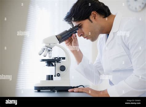 Mixed Race Scientist Peering Into Microscope Stock Photo Alamy