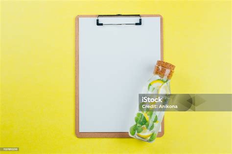 노란색 종이 배경에 이랑 클립 보드와 레몬 민트 물의 디자인 컨셉 플랫 레이 평면도 복사 공간 감귤류 과일에 대한 스톡 사진 및