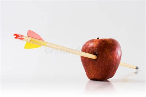 An Apple With Two Wooden Arrows Sticking Out Of It S Side On A White Surface