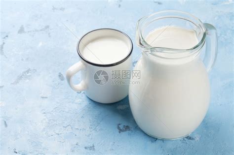 石桌上的牛奶罐和杯子奶制品带复高清图片下载 正版图片502779599 摄图网