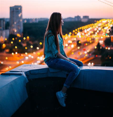 Фото Девушка сидит на крыше здания и смотрит на город Фотограф Ксения
