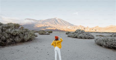 일몰 동안 화산을 배경으로 아름다운 화산 계곡에 밝은 옷을 입은 세련된 여성 스페인 테네리페 섬 여행 사진 Unsplash의 자연 이미지