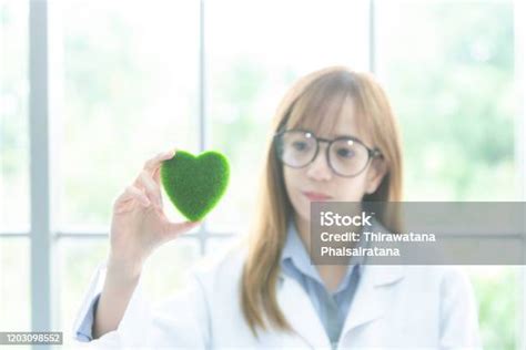 과학 은 녹색 정신 마음 실험실 배경에 그녀의 손에 녹색 마음 아름다운 미소 여성 의사입니다 여자는 병원 실험실에 있습니다