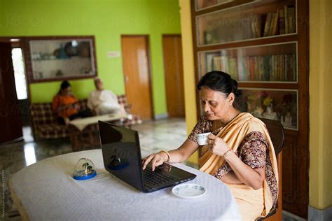 Active Aged Indian Woman Using Laptop Inside Home By Stocksy