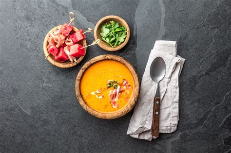 수 박과 Salmorejo 수프입니다 올리브 나무 그릇 슬레이트 배경 상단 보기에 수 박과 햄 세라 노와 함께 전통적인 스페인