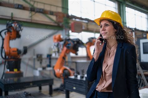 Automation Female Engineer With Tablet For Programming Robotic Arm Calling On Cellphone And